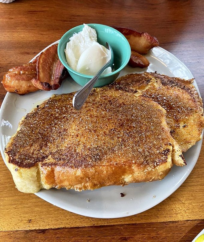 This isn't just French toast—it's a cinnamon-crusted island of joy floating in a sea of possibilities, with vanilla custard as your life raft.