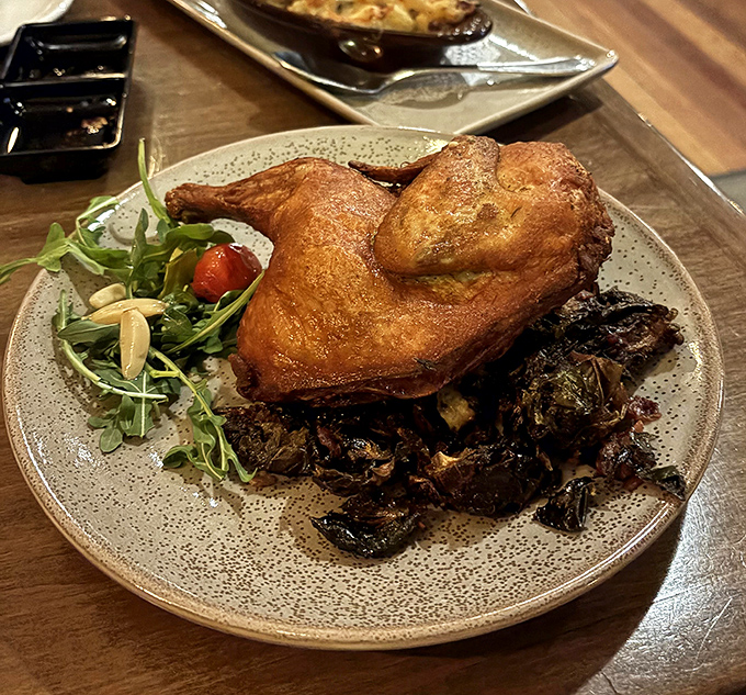 The crispy duck arrives like royalty on a throne of Brussels sprouts. Audible gasps from neighboring tables are completely normal.