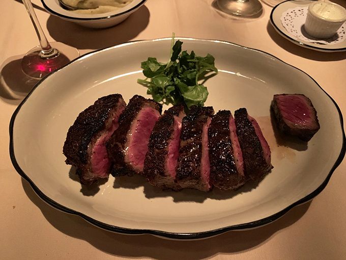 Sliced Delmonico steak showcasing that perfect medium-rare glow. The kind of dish that makes conversation stop mid-sentence while everyone savors the moment.