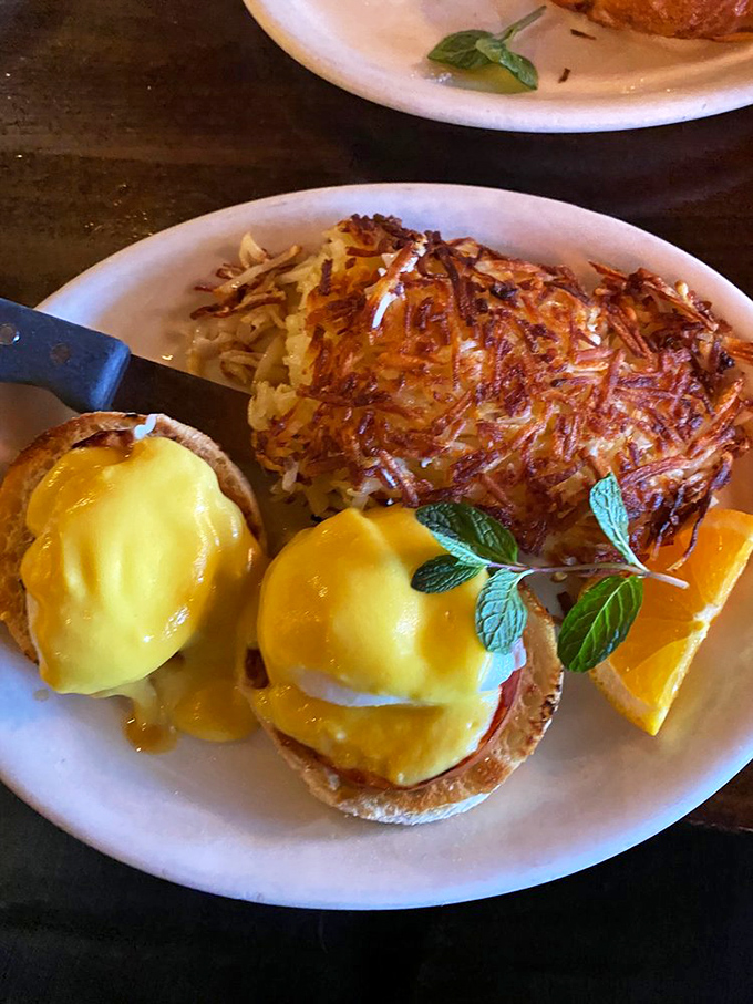 Eggs Benedict done right&mdash;hollandaise cascading like a golden waterfall over English muffins, with hash browns crisped to perfection. Morning salvation on a plate.