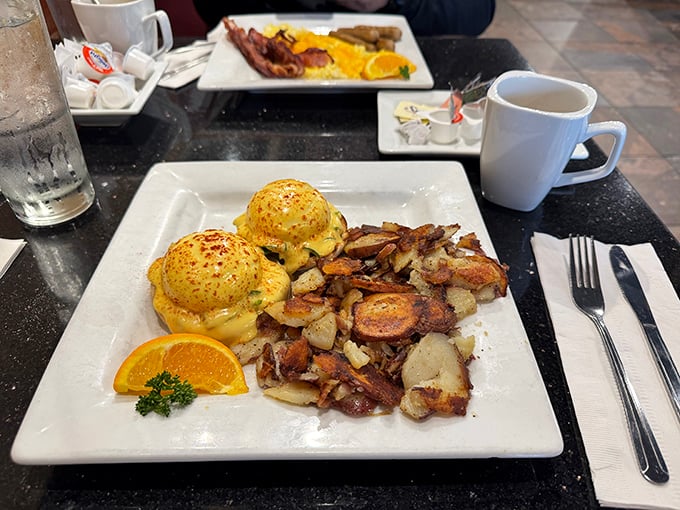 Eggs Benedict: where hollandaise dreams come true. Those golden home fries are the unsung heroes of this breakfast masterpiece.