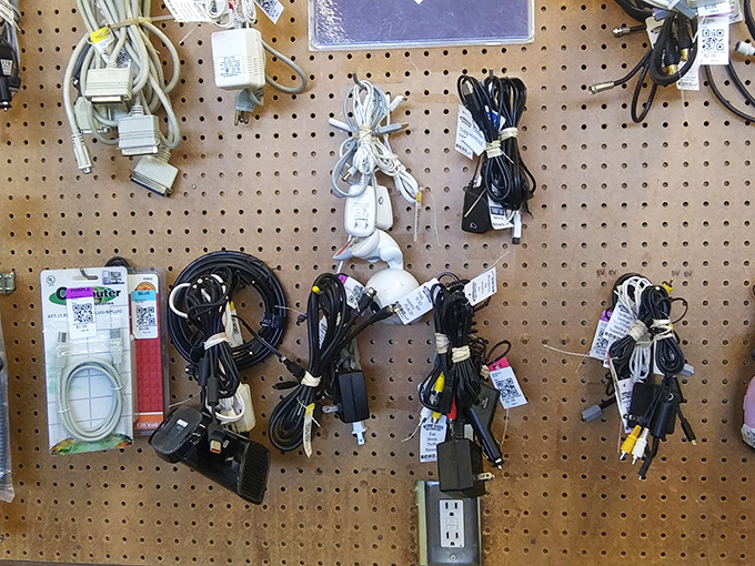 Every cord tells a story of technological evolution hanging like modern art on pegboard walls.