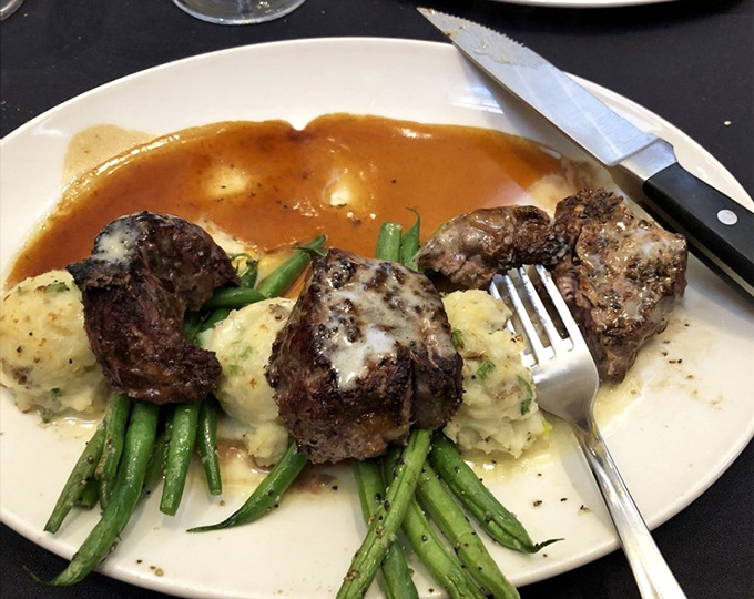 Filet medallions perched atop mashed potatoes and asparagus—proof that sometimes the classics deserve their status. Comfort food with a tuxedo on.