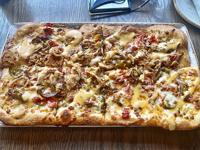 Flatbread that defies gravity with its mountain of toppings. The drizzle of sauce is like the final brushstroke on a culinary masterpiece.