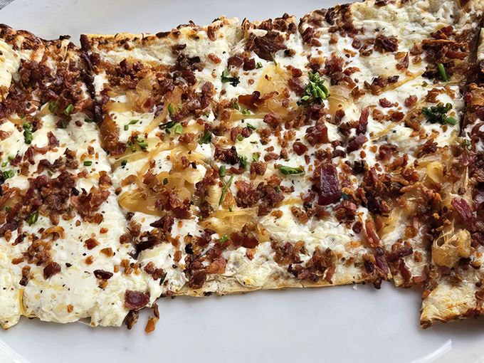 This isn't your average flatbread&mdash;it's a crispy canvas of melted cheese, caramelized onions, and bacon bits that would make even a German grandmother nod in approval.