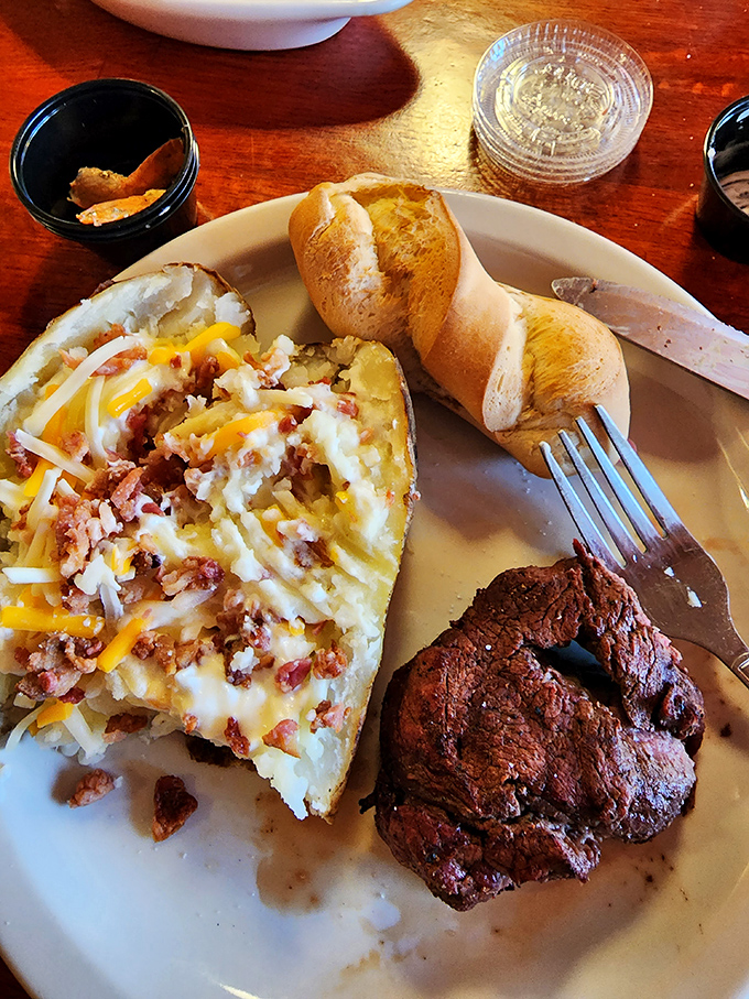 A loaded potato dressed for success, paired with a filet mignon that melts faster than your willpower in a bakery.