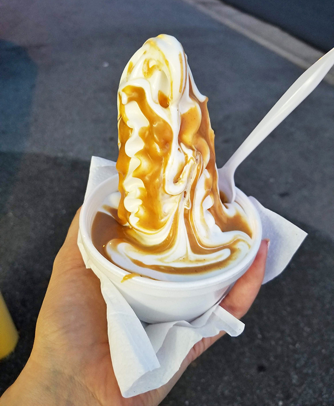 Caramel rivers cascade over vanilla peaks, creating a landscape so beautiful you almost feel guilty destroying it. Almost.