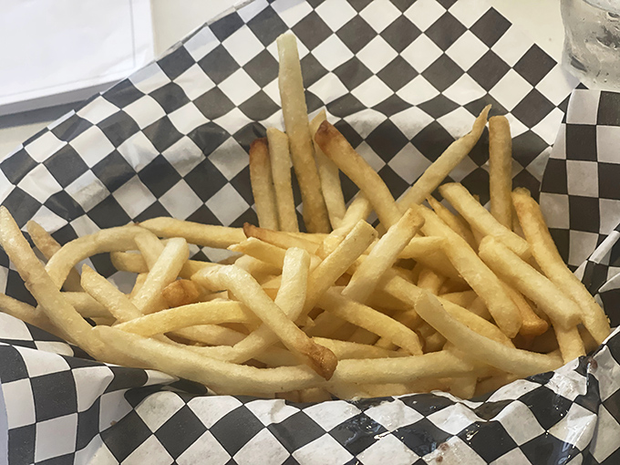 These aren't just french fries; they're golden happiness sticks, crisp on the outside, fluffy within, served in that iconic checkered paper that signals good times ahead.