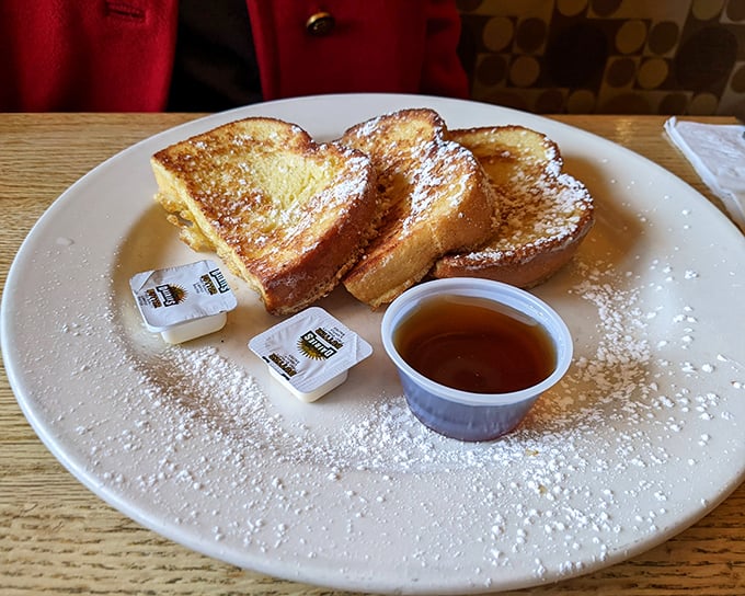 French toast so perfectly golden it belongs in Fort Knox, dusted with powdered sugar like the first perfect snowfall of winter.