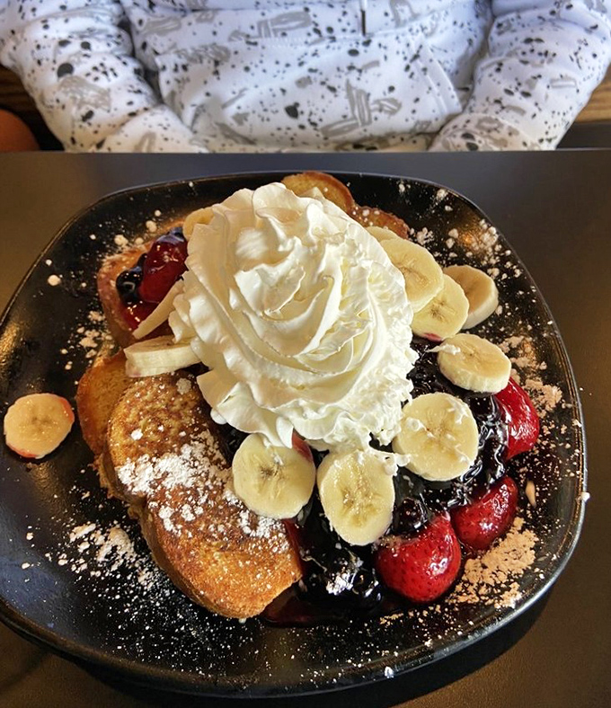 French toast that's dressed for success with berries, bananas, and enough whipped cream to make your cardiologist wince delightfully.