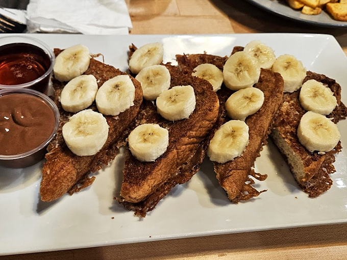 French toast gets the VIP treatment with fresh bananas standing at attention, ready to dive into pools of syrup.