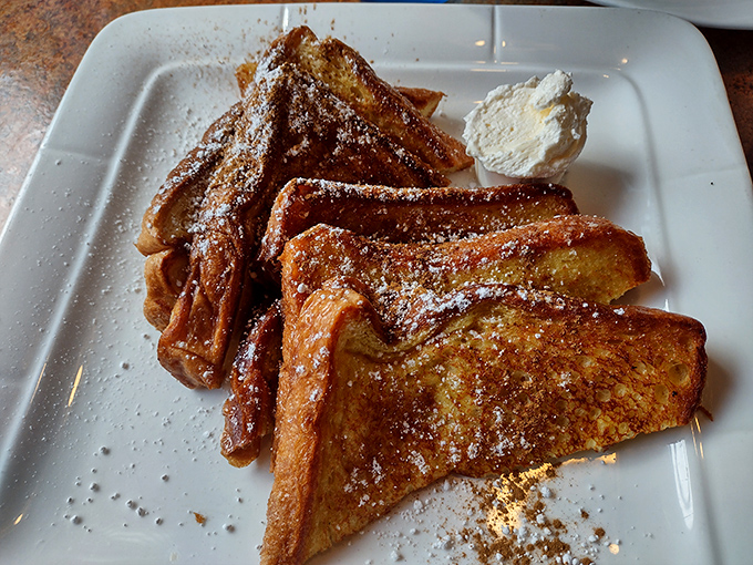 French toast that's crossed the line from breakfast to dessert territory, dusted with powdered sugar and ready to make your morning absolutely magnificent.