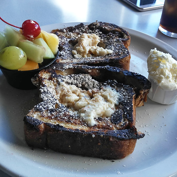 French toast that's having an identity crisis as dessert. The fruit cup is there to maintain the illusion that breakfast isn't cake.