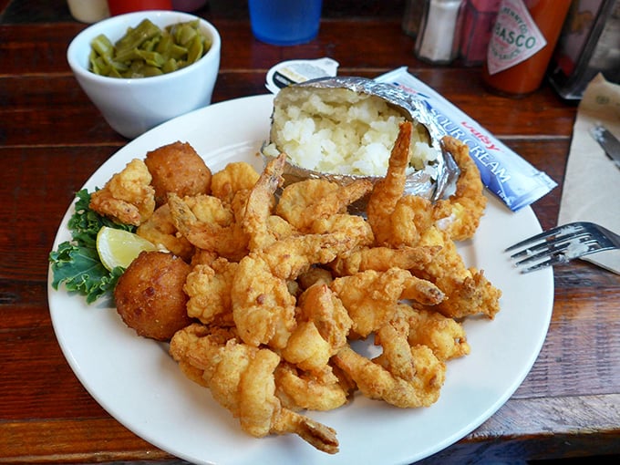 A plate of perfectly fried shrimp alongside a baked potato that's dressed for success. This isn't just dinner&mdash;it's coastal Georgia on a plate.
