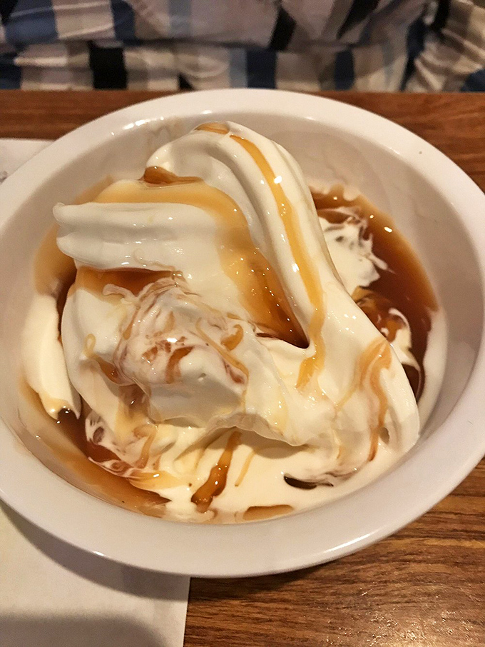 Soft-serve ice cream drizzled with caramel sauce&mdash;proof that sometimes the simplest desserts deliver the most profound happiness.