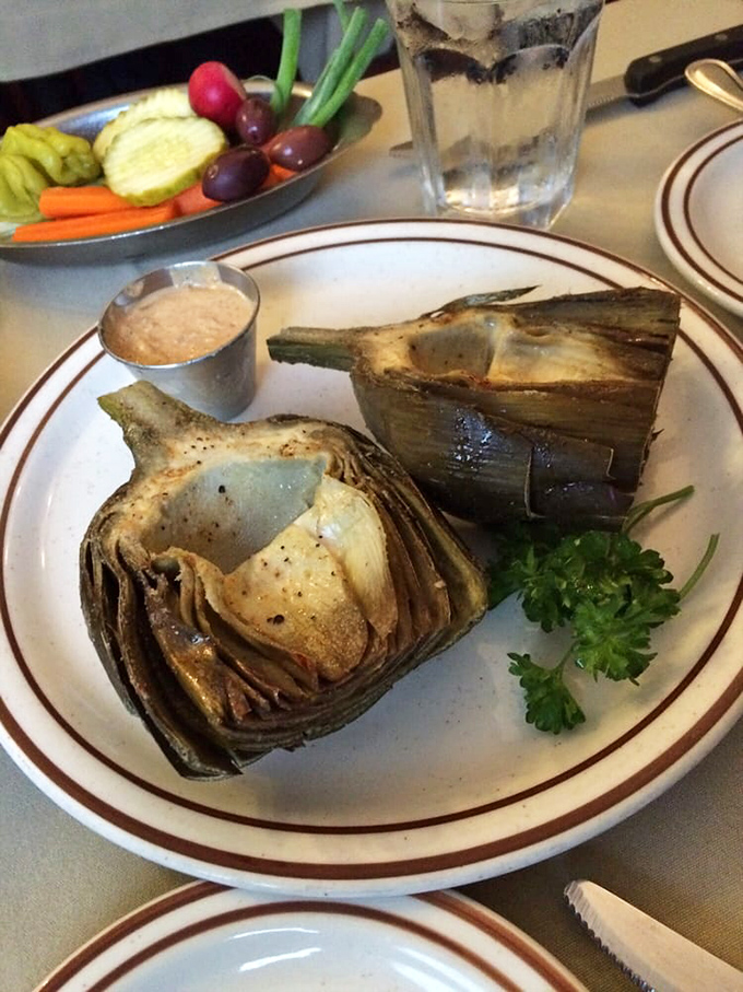 Grilled artichokes arrive like edible sculptures, kissed by oak smoke and begging to be dipped in that house-made sauce.