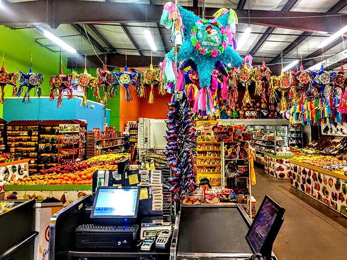 A fiesta for the senses! Colorful pi&ntilde;atas hang above produce displays, creating a vibrant marketplace atmosphere that awakens childhood memories.