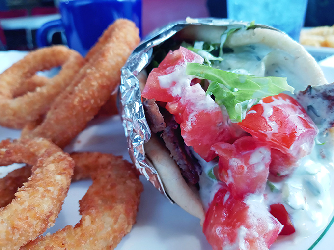 This isn't just a gyro&mdash;it's edible architecture. Crispy onion rings standing guard beside a sandwich that requires both hands and several napkins.