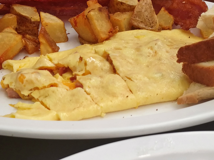 This isn't just an omelet&mdash;it's a fluffy yellow canvas painted with melted cheese and paired with home fries that could make a potato farmer weep with joy.