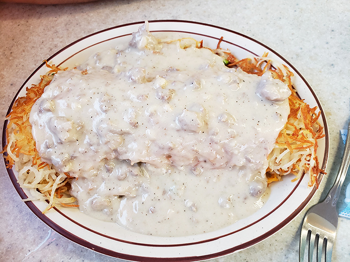 Hashbrowns smothered in country gravy&mdash;where crispy potato meets creamy, peppery heaven in a marriage that would make cardiologists nervous.