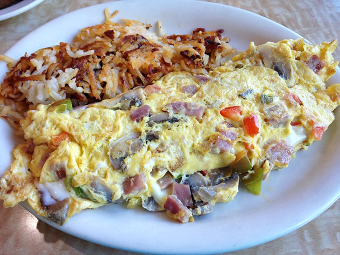 This isn't just an omelet; it's a masterpiece of morning architecture with perfectly crisped home fries standing guard alongside. Breakfast of champions, indeed.