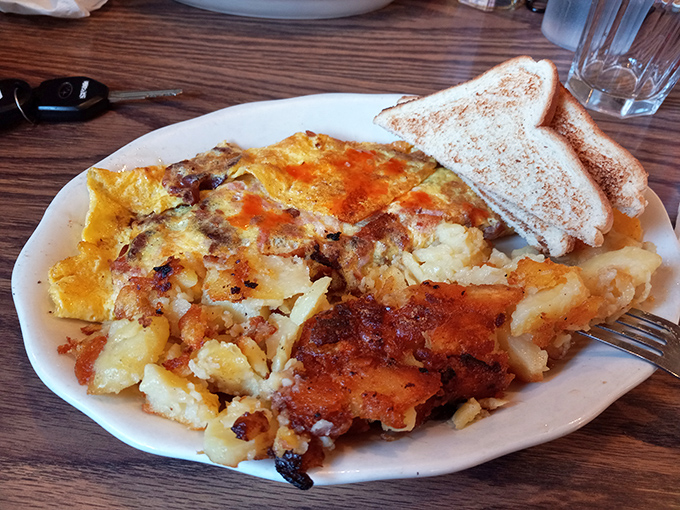 This omelet doesn't just share the plate with home fries &ndash; they're dance partners in a breakfast tango that's been perfected over decades.