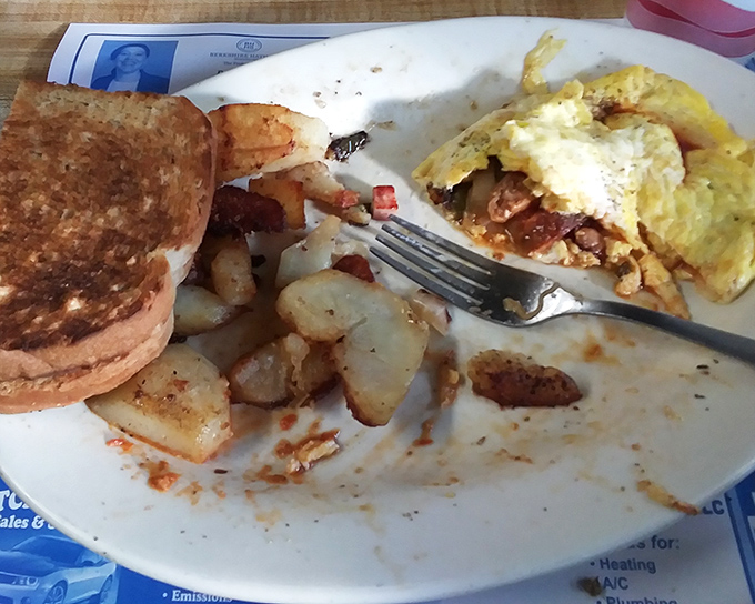 Breakfast perfection captured mid-bite. Those home fries and eggs tell the story of countless mornings spent in good company with better food.