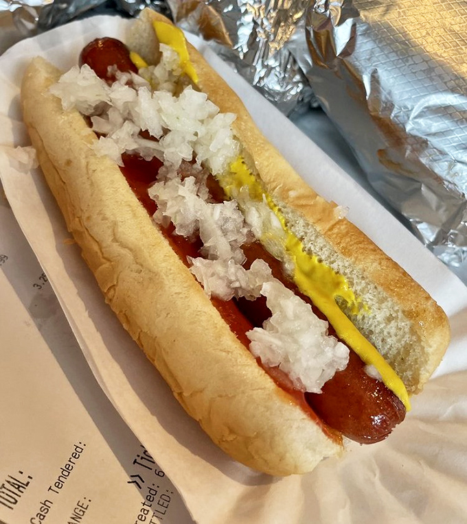 Hot dog royalty! Perfectly nestled in a pillowy bun with mustard and onions&mdash;proof that simplicity, when done right, is the ultimate sophistication.