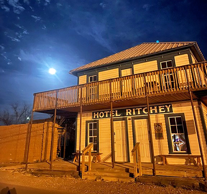 Hotel Ritchey glows under moonlight like a frontier-era postcard come to life, offering accommodations with more character than a Coen brothers film. 