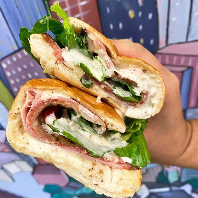 This Italian sub cross-section reveals the architectural genius behind Mickey's creations &ndash; perfect meat-to-cheese ratios and fresh greens creating a harmonious flavor symphony.