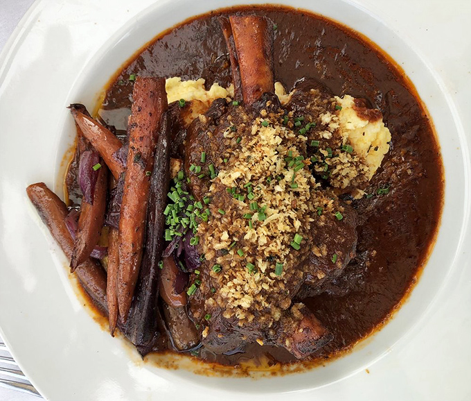 This lamb shank swims in rich gravy like it's auditioning for a starring role in your food fantasies.