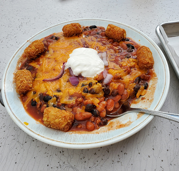 This isn't just chili—it's a warm hug in a bowl. Those tater tots standing guard around the perimeter? Pure genius.
