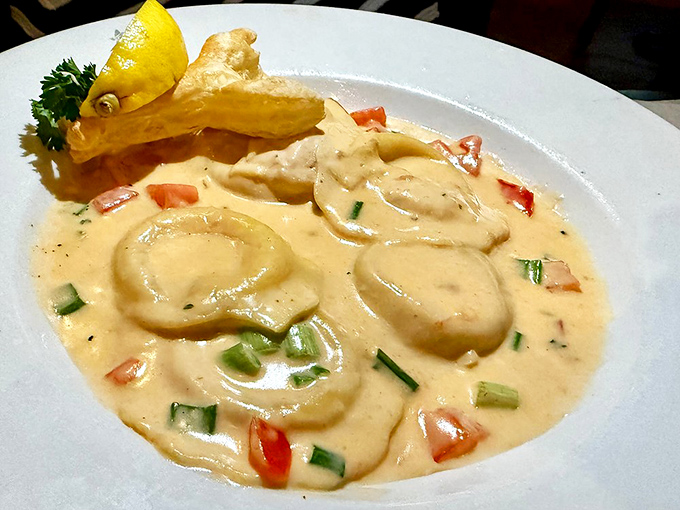 Lobster ravioli swimming in creamy sauce—proof that pasta can indeed achieve its highest purpose when seafood gets involved.