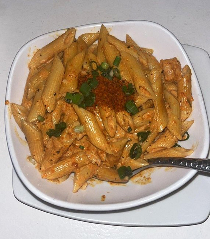 Pasta that's dressed to impress. This penne dish, crowned with fresh scallions and spice, proves Strip isn't just a one-trick pony.