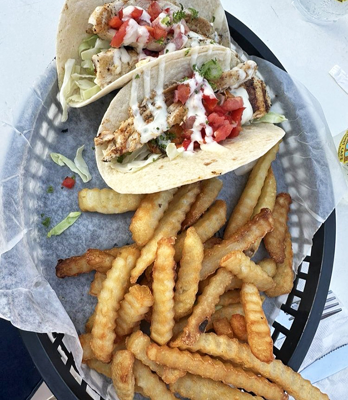 Fish tacos done right: fresh mahi, crisp veggies, and those perfectly golden fries that somehow taste better with sand between your toes.