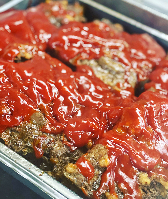 Meatloaf wearing its red sauce crown like Southern royalty. This isn't your Monday night desperation dinner; this is what meatloaf dreams of becoming.