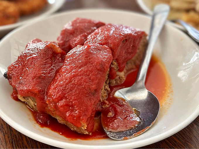 This meatloaf isn't just comfort food; it's a hug on a plate, draped in tomato sauce that could make a vegetarian reconsider their life choices.