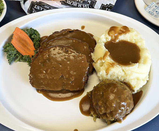Meatloaf swimming in gravy with a side of nostalgia. The kind of plate that makes you wonder why you ever bothered with fancy restaurants.