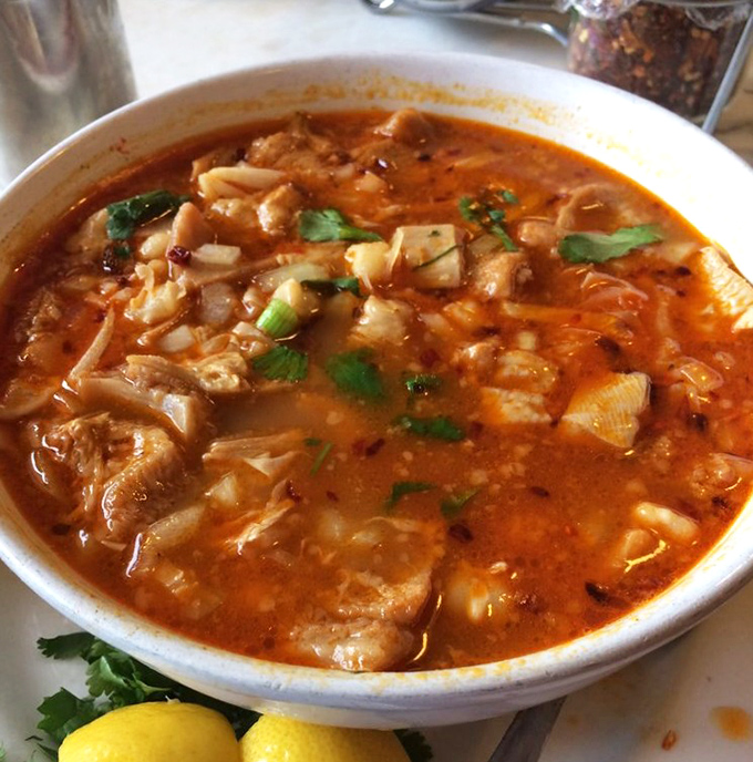 This menudo isn't just soup; it's a spicy, soul-warming ritual in a bowl, garnished with fresh cilantro and a squeeze of sunshine.
