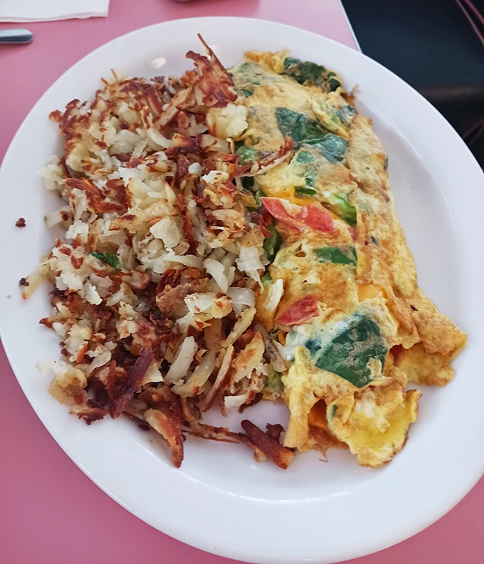 This isn't just an omelet&mdash;it's an edible love letter to vegetables, folded into fluffy eggs and served with hash browns that crackle with each bite.