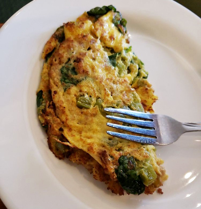 This isn't just an omelet; it's a vegetable-studded canvas of breakfast artistry that makes you wonder why you ever settled for cereal.