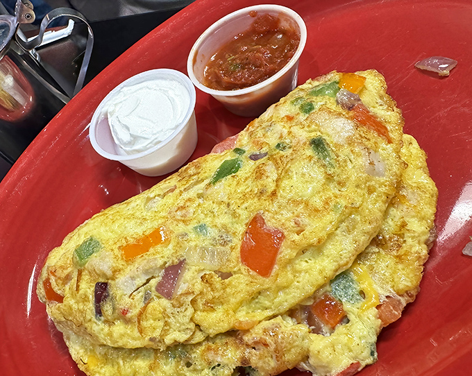 Behold the omelet of champions! Fluffy egg perfection stuffed with colorful veggies and served with all the necessary accompaniments.