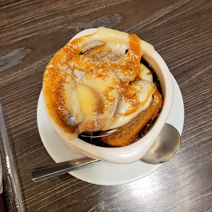 This French onion soup isn't just comfort food; it's a warm hug in a bowl with a gooey cheese lid that stretches dramatically with each spoonful.