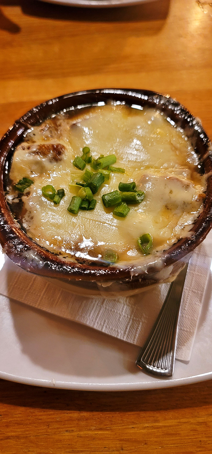 This isn't just onion soup&mdash;it's a bubbling cauldron of comfort topped with a golden cheese canopy that stretches with each spoonful.