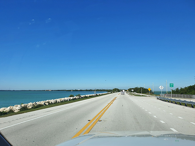 The road stretches ahead like an invitation, with water so blue it makes the sky jealous.