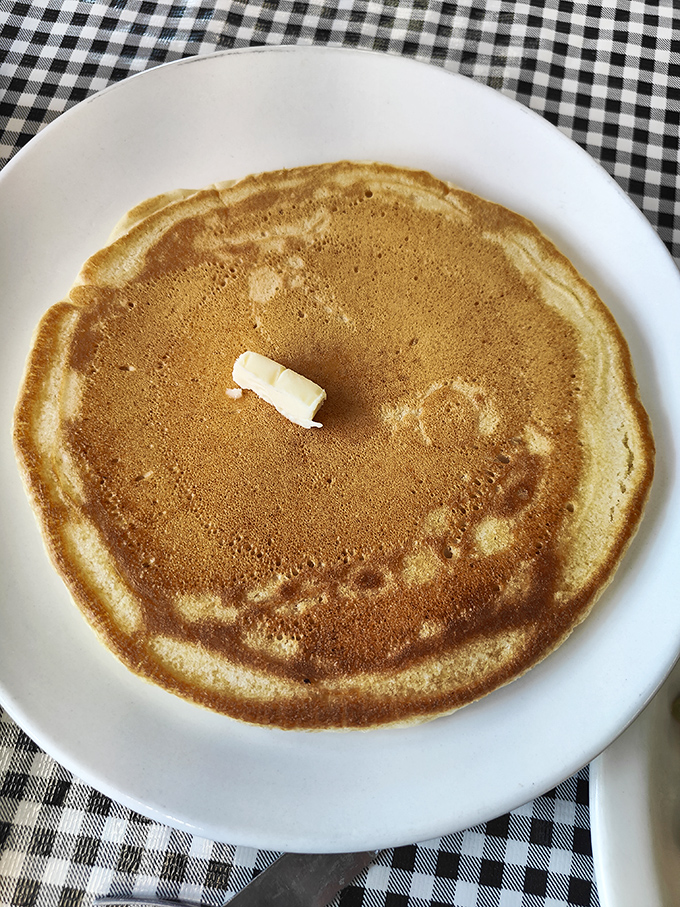Behold the pancake in its natural habitat &ndash; golden, perfectly round, with butter slowly melting into its warm embrace. Simplicity at its most delicious.