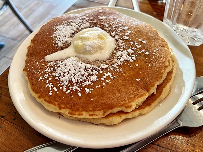 Pancakes that achieve the impossible: perfectly golden with a dollop of butter slowly melting into a warm, fluffy landscape of breakfast bliss.