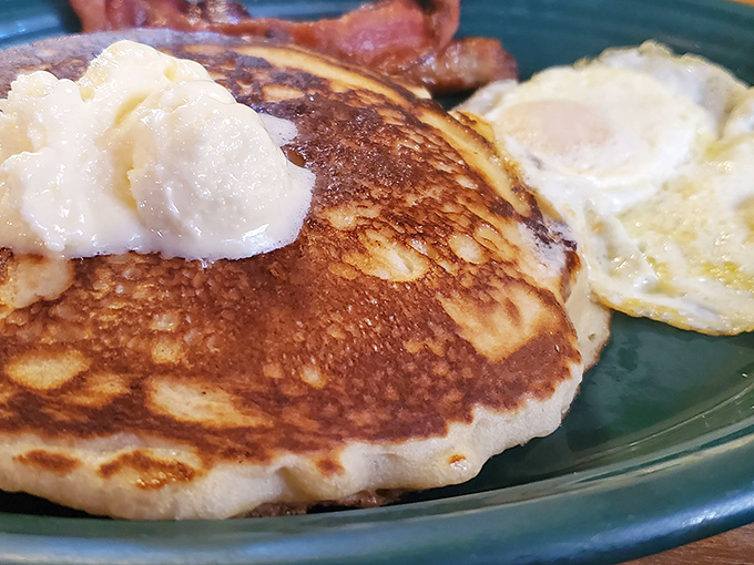 When pancakes meet perfection on a plate, accompanied by eggs that know their supporting role beautifully.