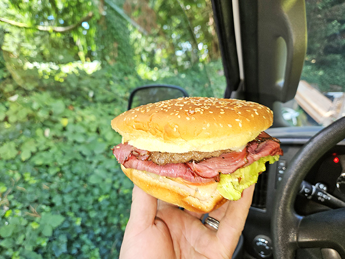 Road food nirvana! The pastrami burger enjoyed in the car proves some of life's greatest pleasures don't require a table, just a hungry spirit.