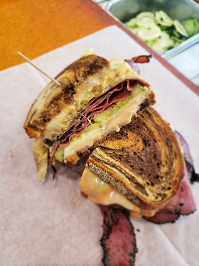 This isn't just a sandwich; it's architecture. Layers of pink pastrami, melted cheese, and pickles creating the Taj Mahal of lunch options.